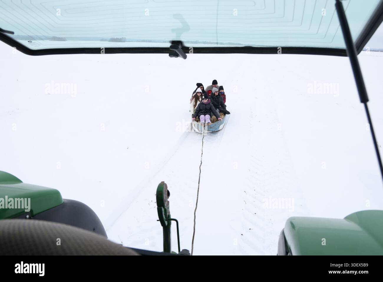 A tractor pulls people on a boat sled at snow covered field in Vinkovci ...