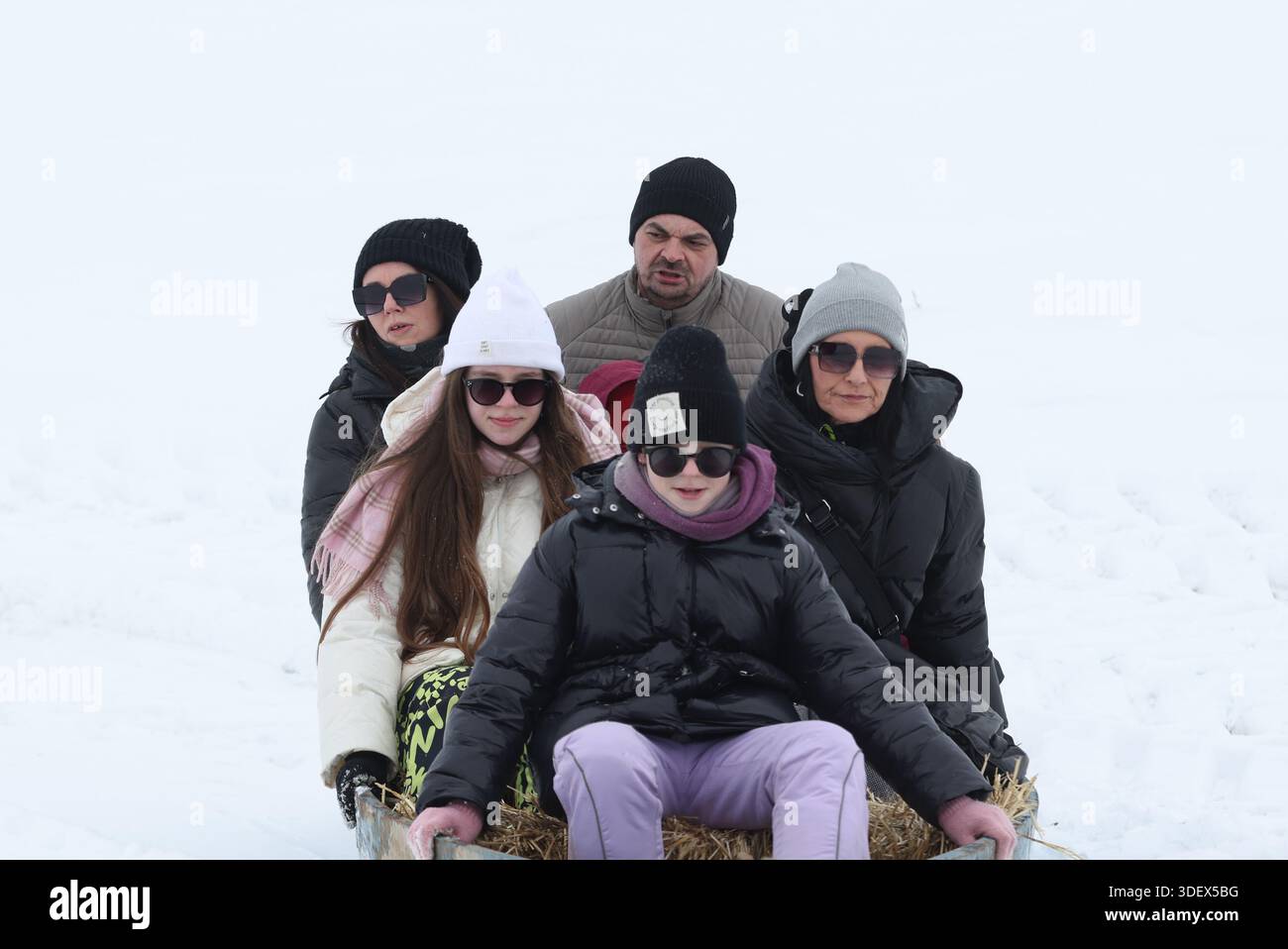 A tractor pulls people on a boat sled at snow covered field in Vinkovci ...