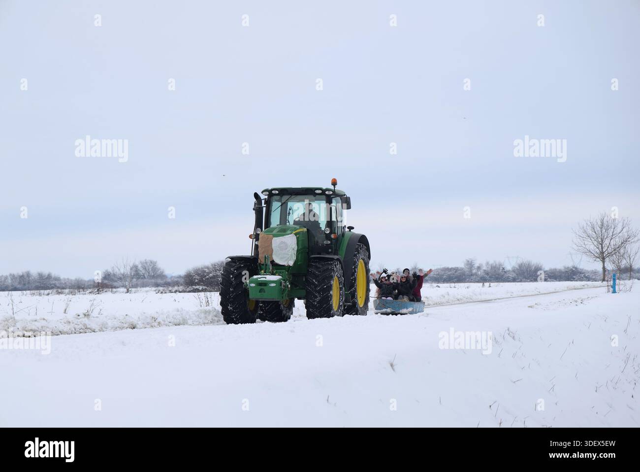A tractor pulls people on a boat sled at snow covered field in Vinkovci ...