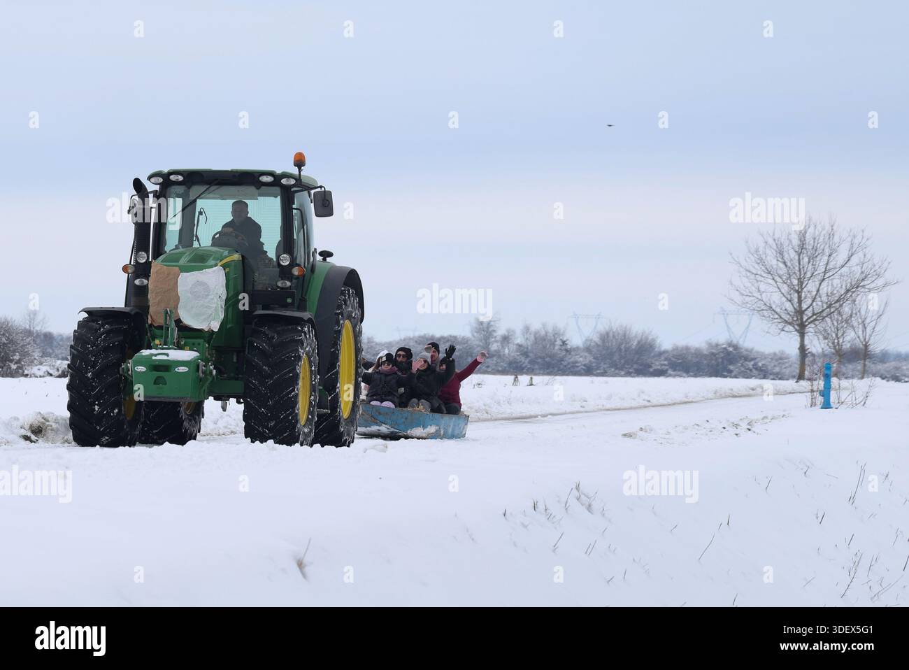 A tractor pulls people on a boat sled at snow covered field in Vinkovci ...