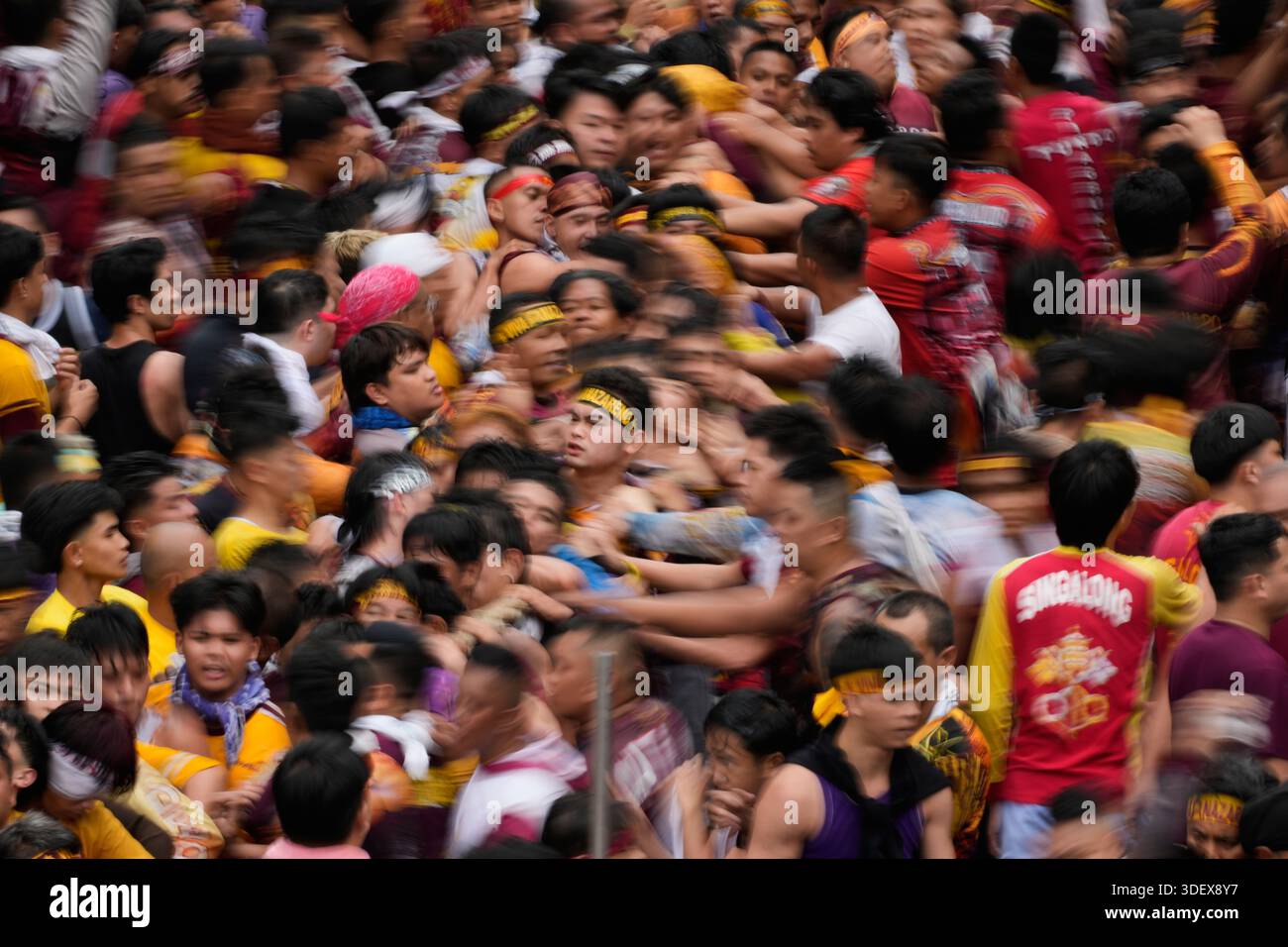 Catholic devotees pull a rope tied to the carriage carrying the image ...