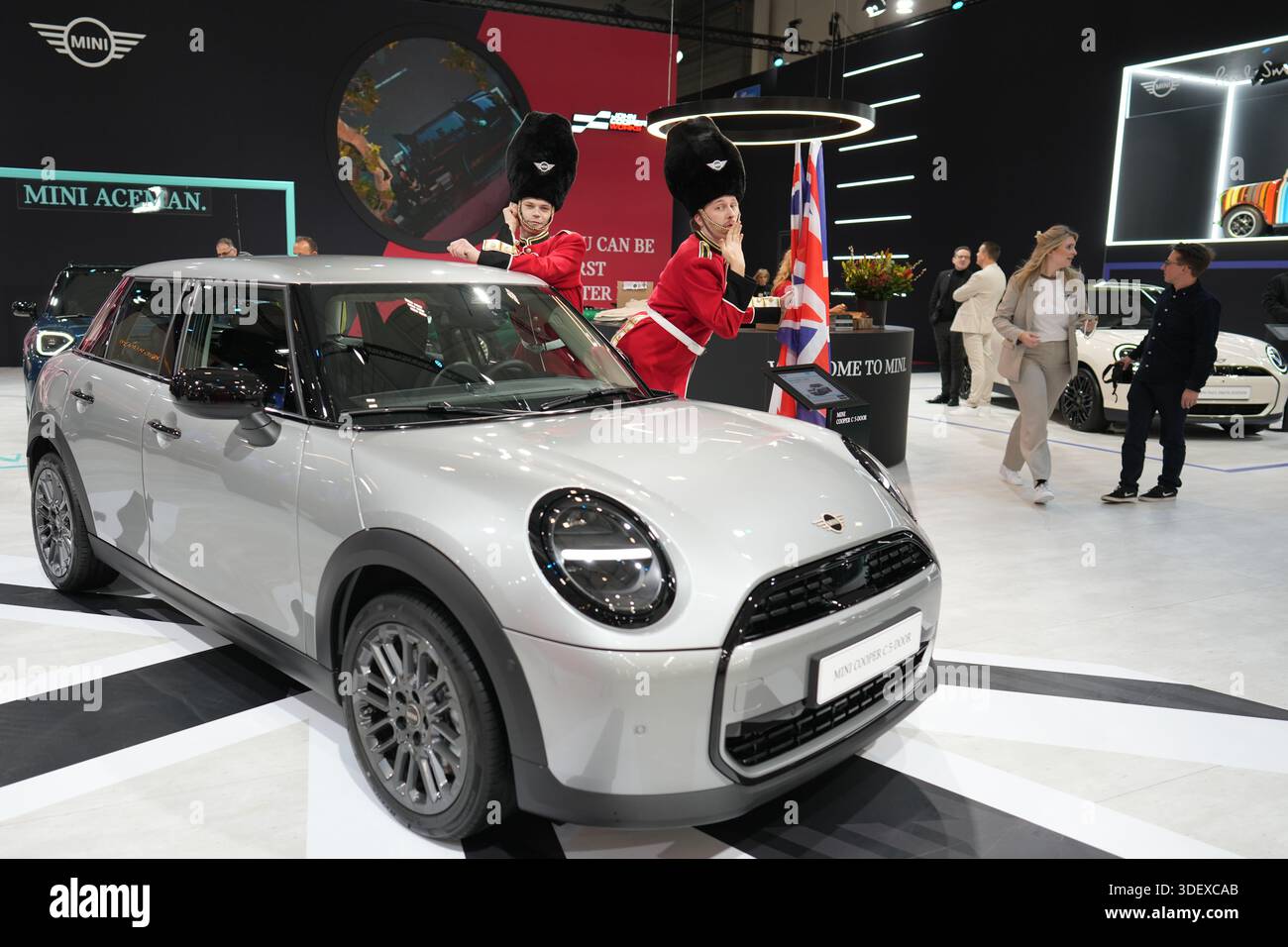 Two presenters pose next to the Mini Cooper C 5 door during the media ...