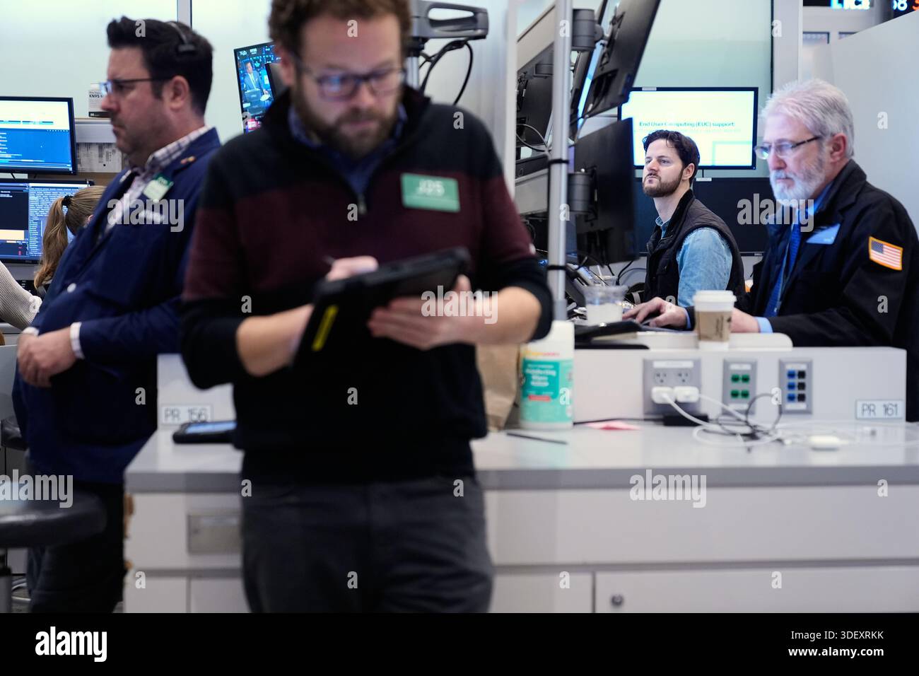 Traders work on the floor at the New York Stock Exchange in New York ...