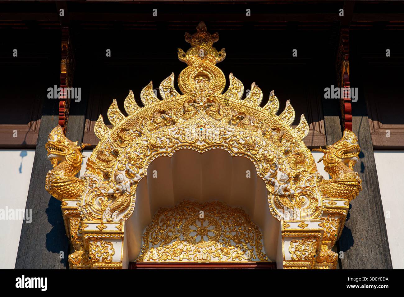 Intricate golden Lanna-style wood carvings on the pediment of Ho Kham ...