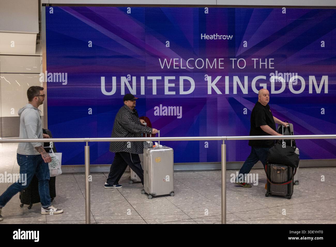 Travelers walking pass a welcome to the United Kingdom at Heathrow ...