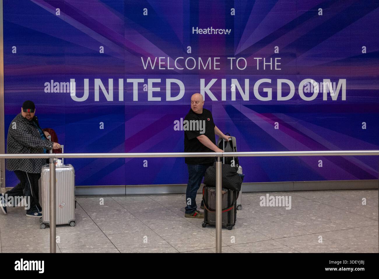 Travelers walking pass a welcome to the United Kingdom at Heathrow ...