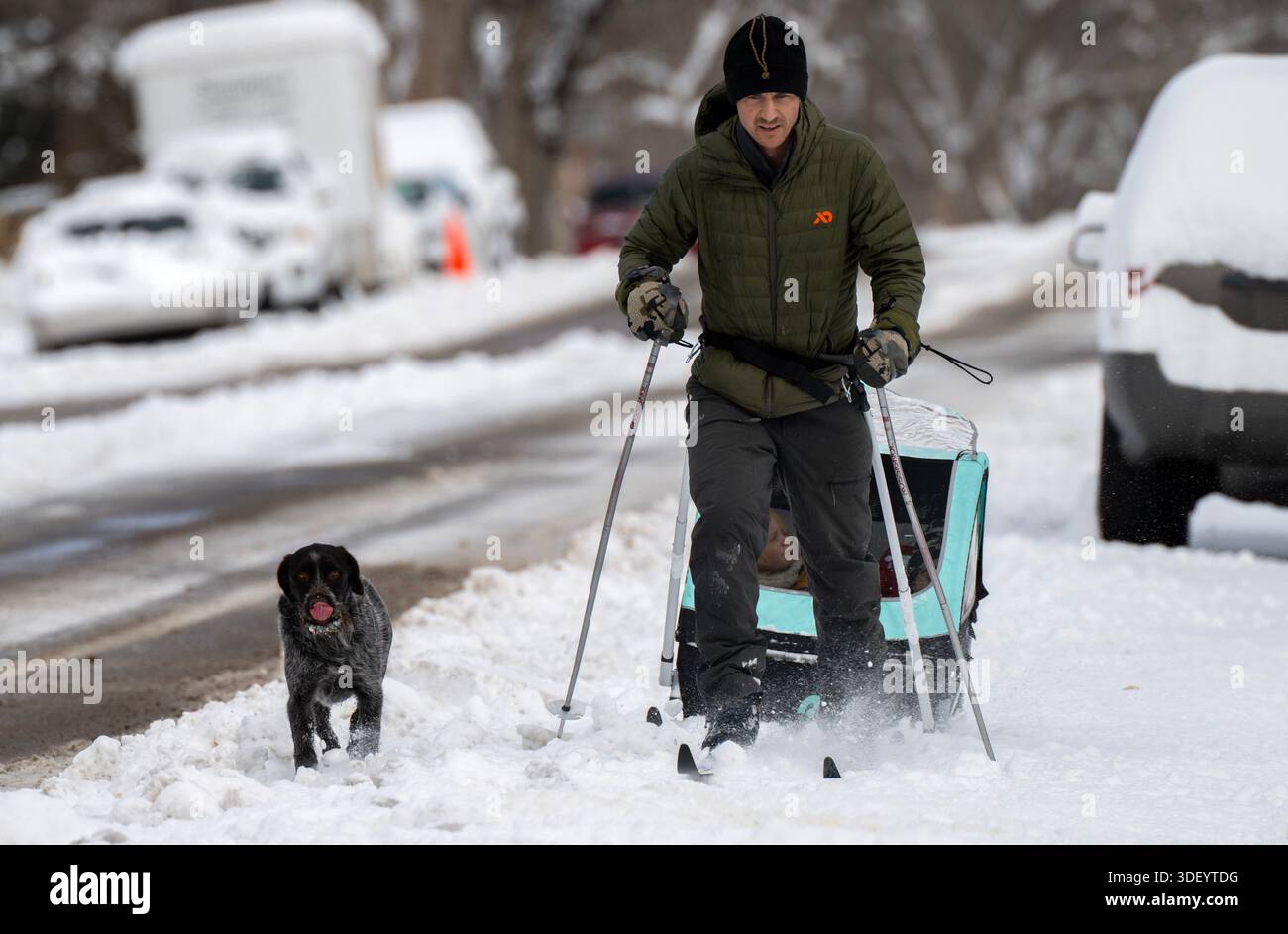 Jordan Burt tows his children, Weston, 4, and Wrenly, 2, as he skis to ...