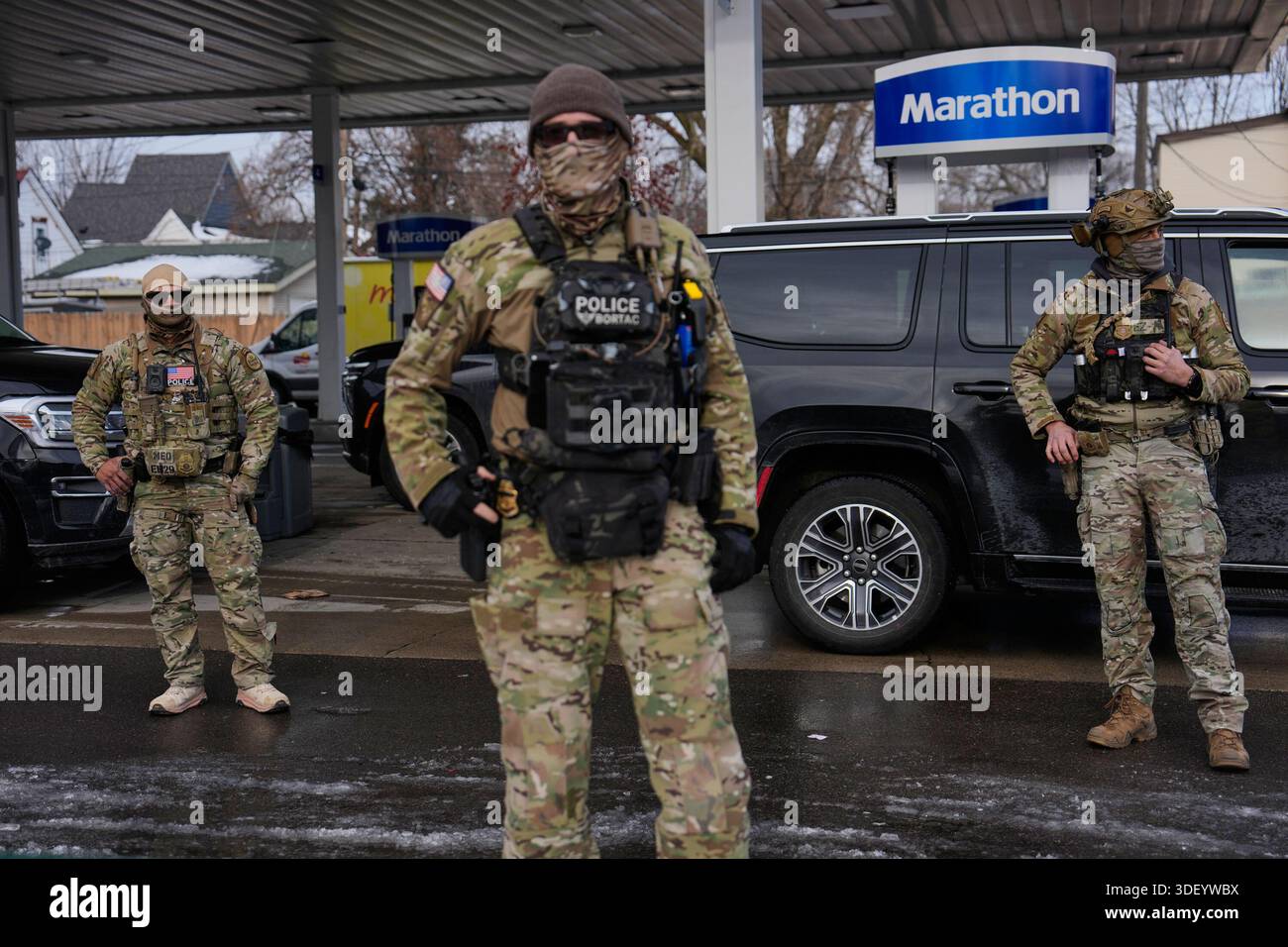 Federal law enforcement agents stand at a gas station while on patrol ...