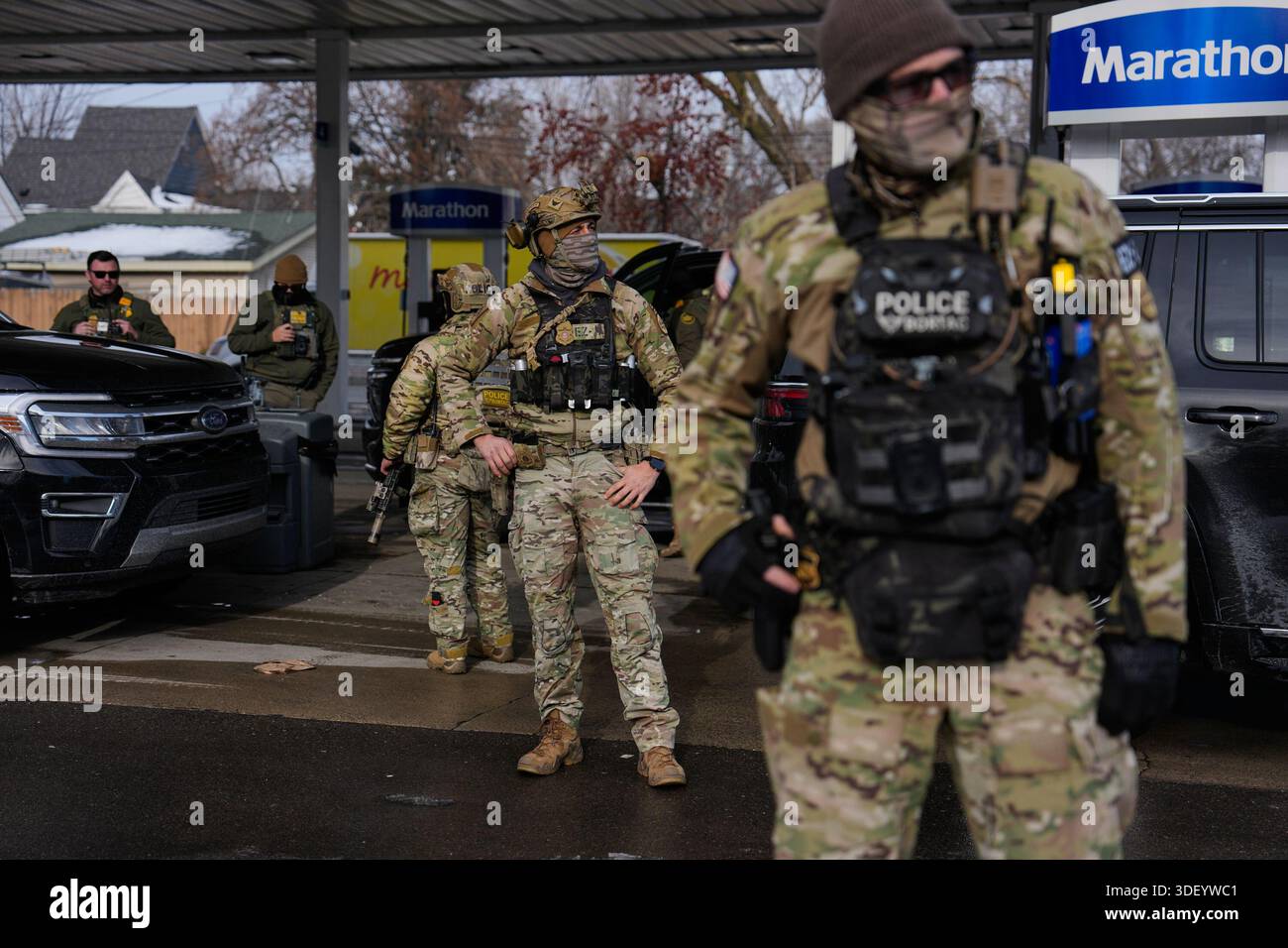 Federal law enforcement agents stand at a gas station while on patrol ...