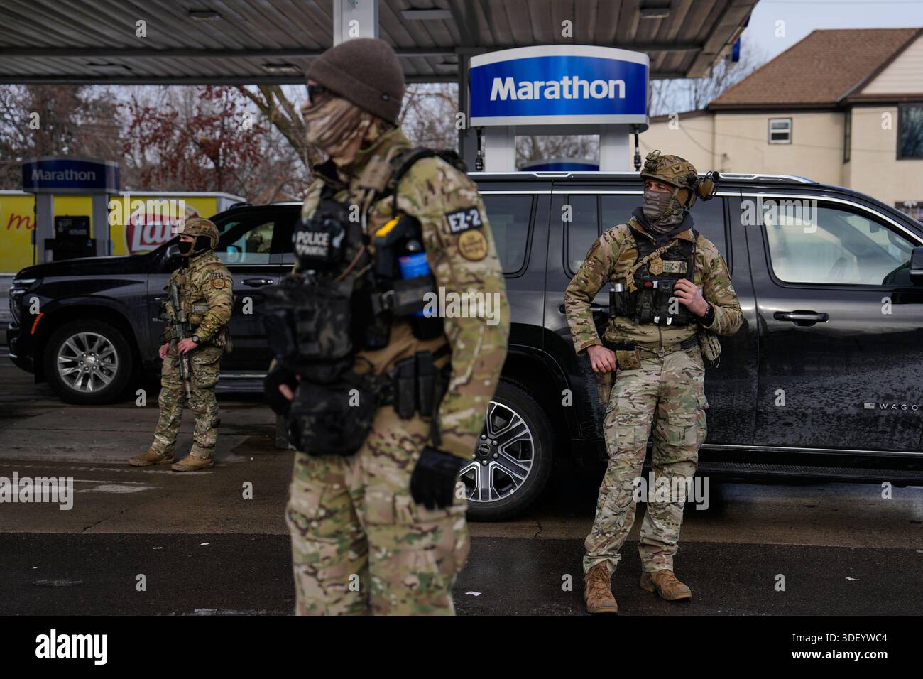 Federal law enforcement agents stand at a gas station while on patrol ...