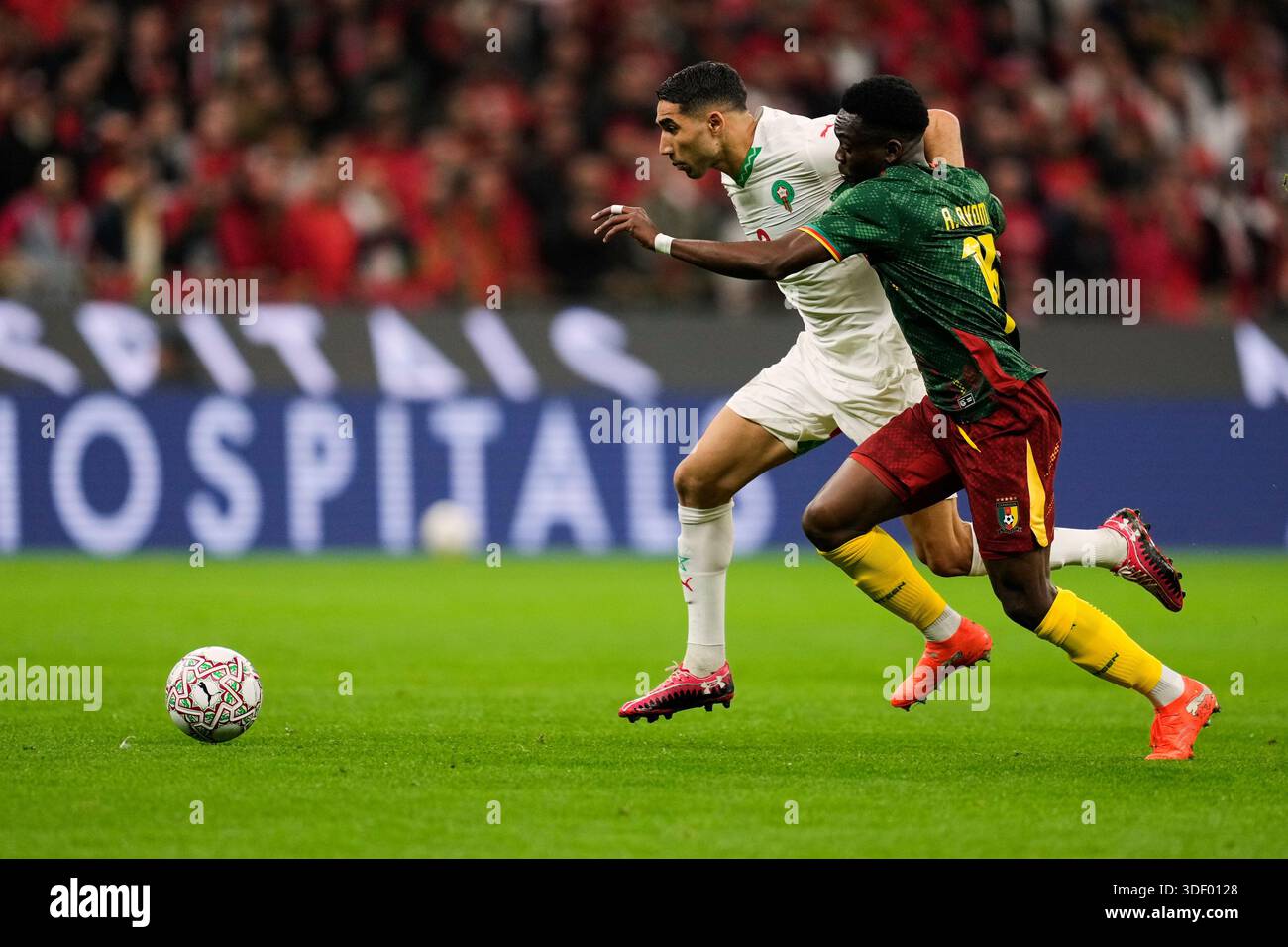 Morocco's Achraf Hakimi is challenged by Cameroon's Arthur Avom, right ...