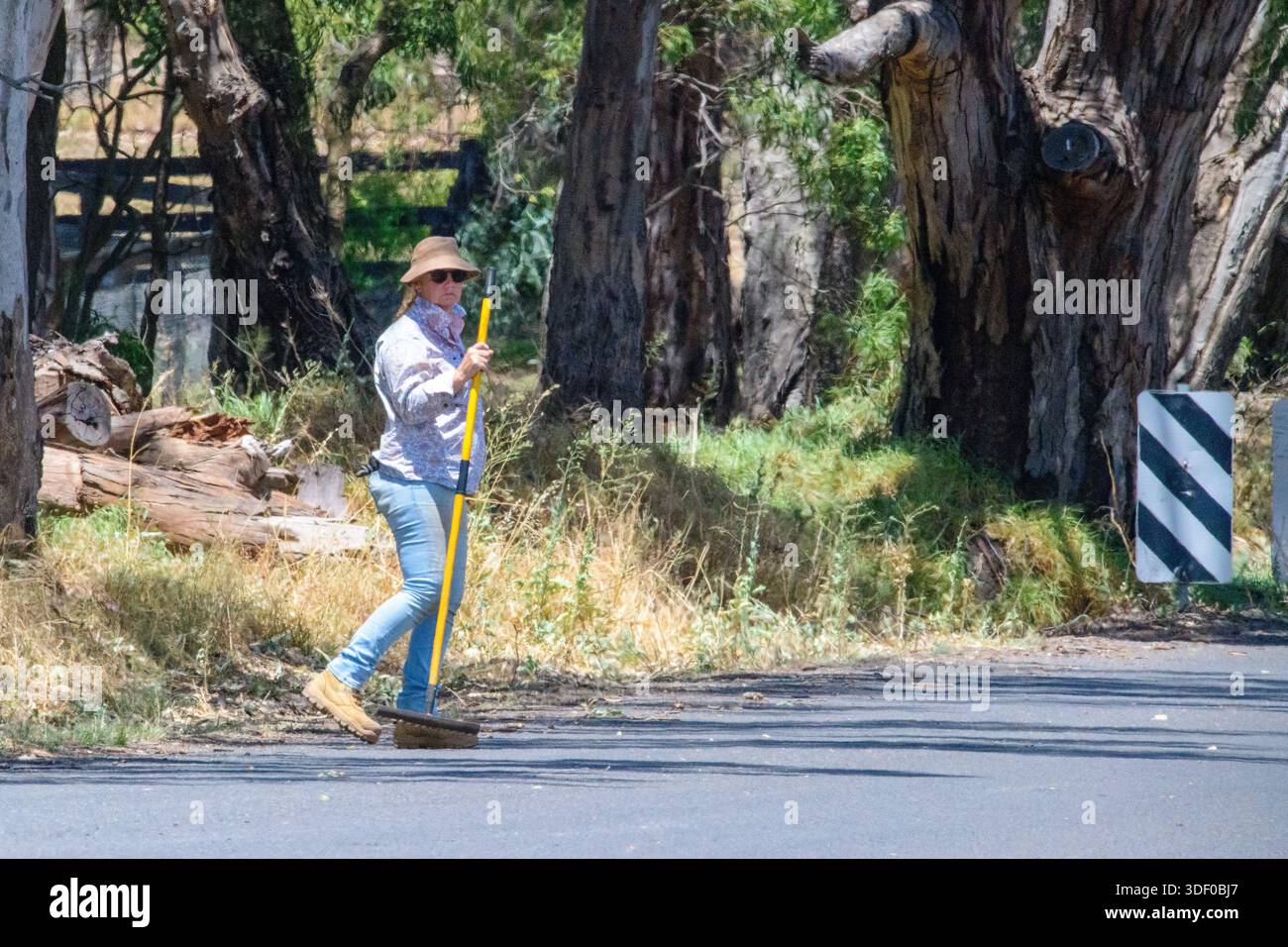 A resident keeps a watch for sparks and burning debris from a roadside ...