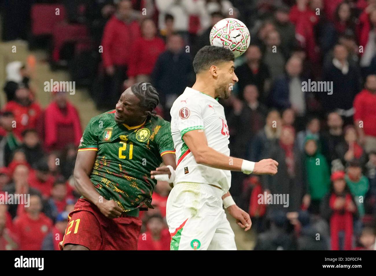 Morocco's Adam Masina, right, jumps for a header with Cameroon's Karl ...