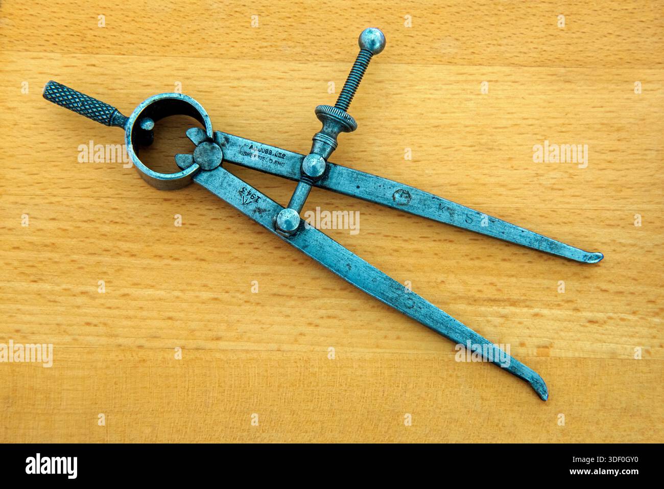 Old, vintage well used caliper, made in Sheffeld on wooden background ...