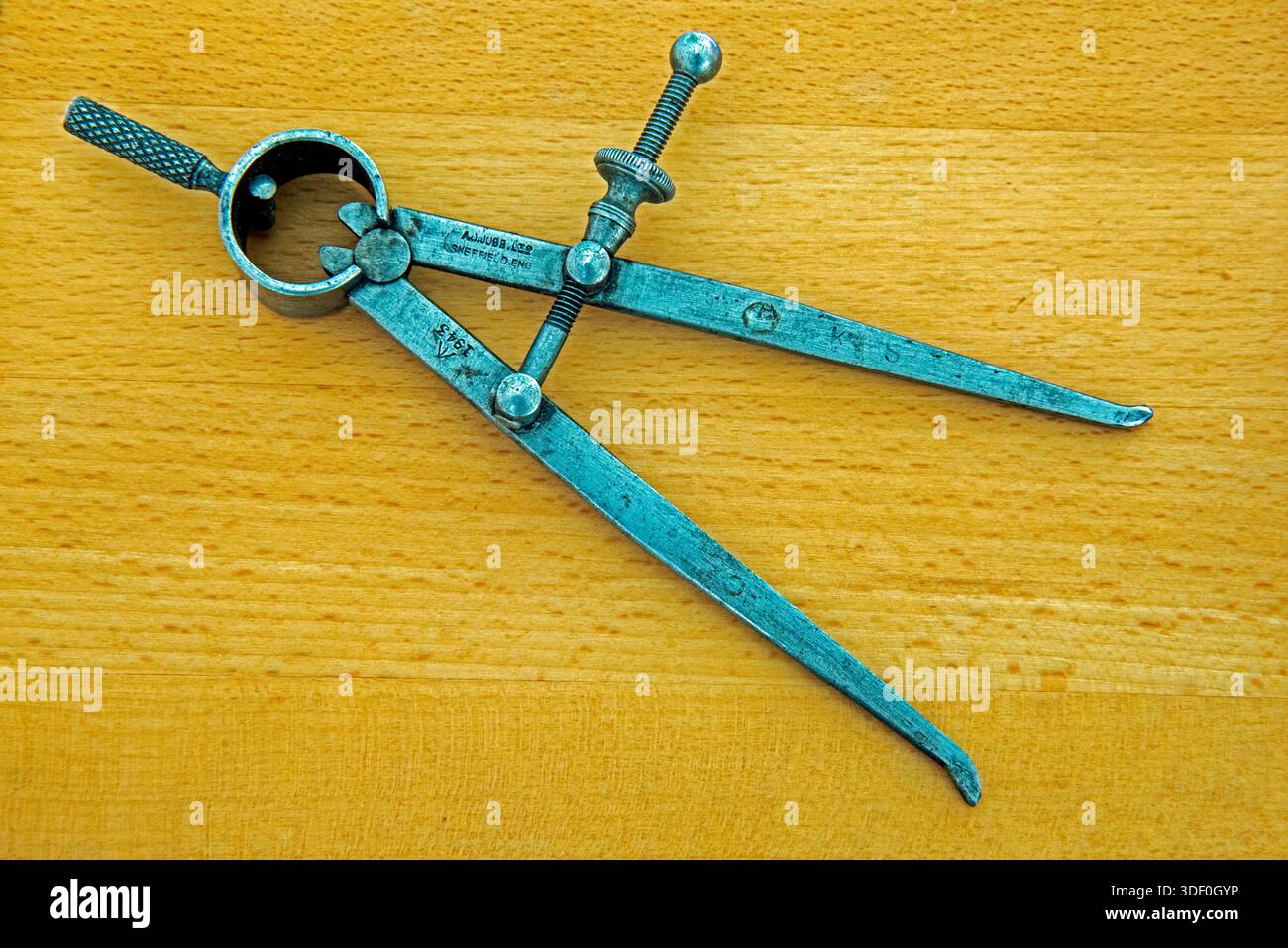 Old vintage well used calipers, made in Sheffield on wooden background ...