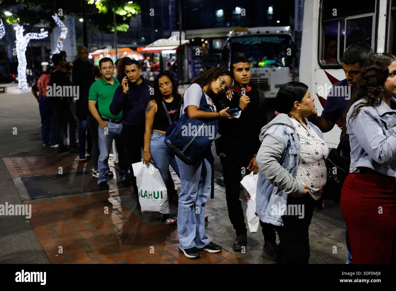 People wait for transportation at a bus stop in Caracas, Venezuela ...