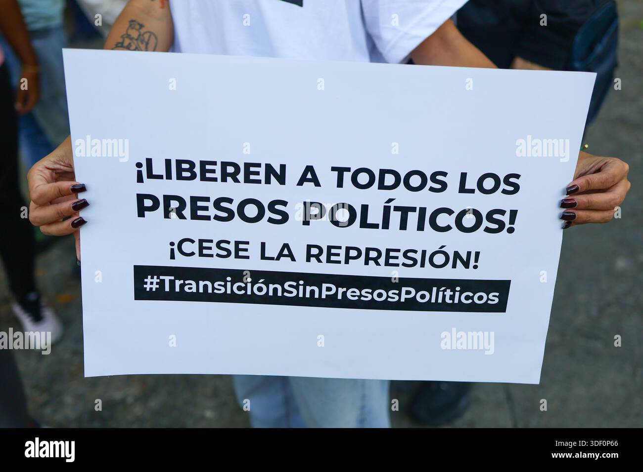 09 January 2026, Venezuela, Caracas: A demonstrator holds a sign near ...