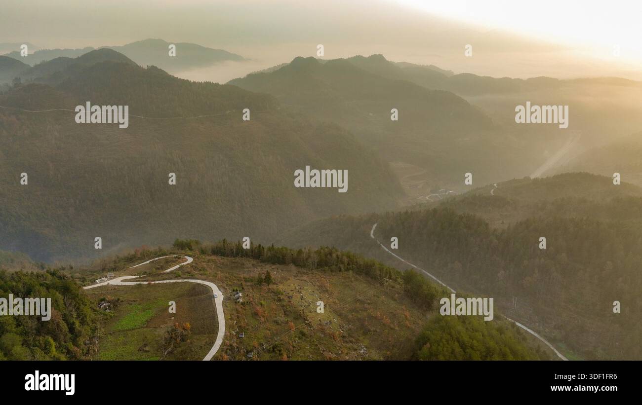 The morning sun rises over mountains as mist lingers in Dingshi Town ...