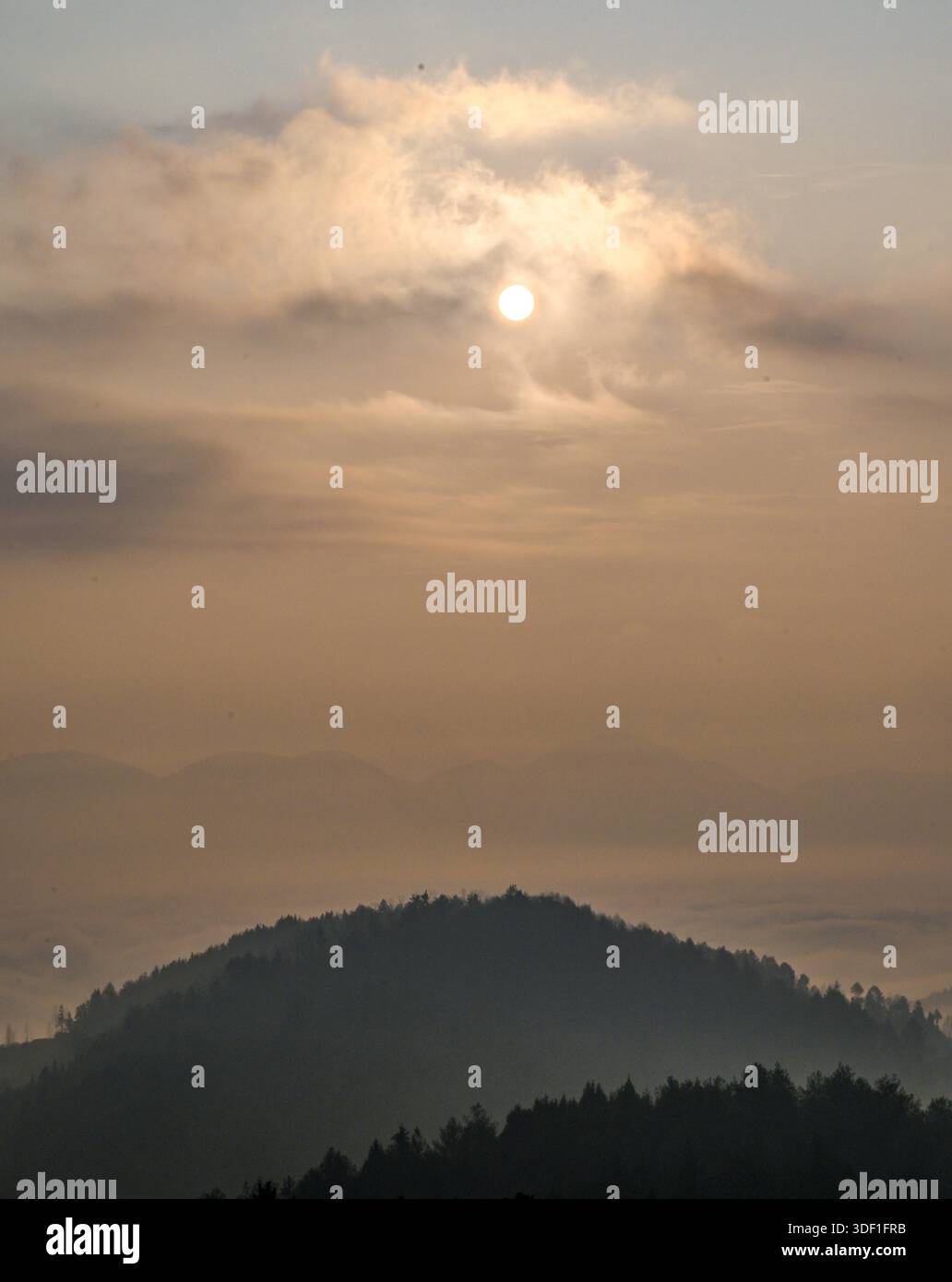 The morning sun rises over mountains as mist lingers in Dingshi Town ...