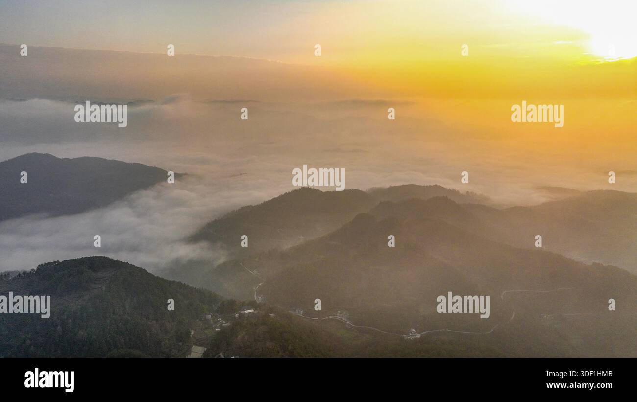The morning sun rises over mountains as mist lingers in Dingshi Town ...