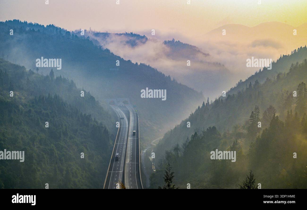 The morning sun rises over mountains as mist lingers in Dingshi Town ...