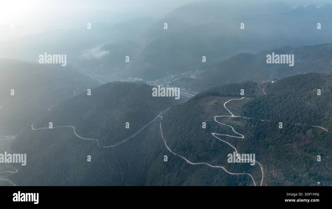 The morning sun rises over mountains as mist lingers in Dingshi Town ...