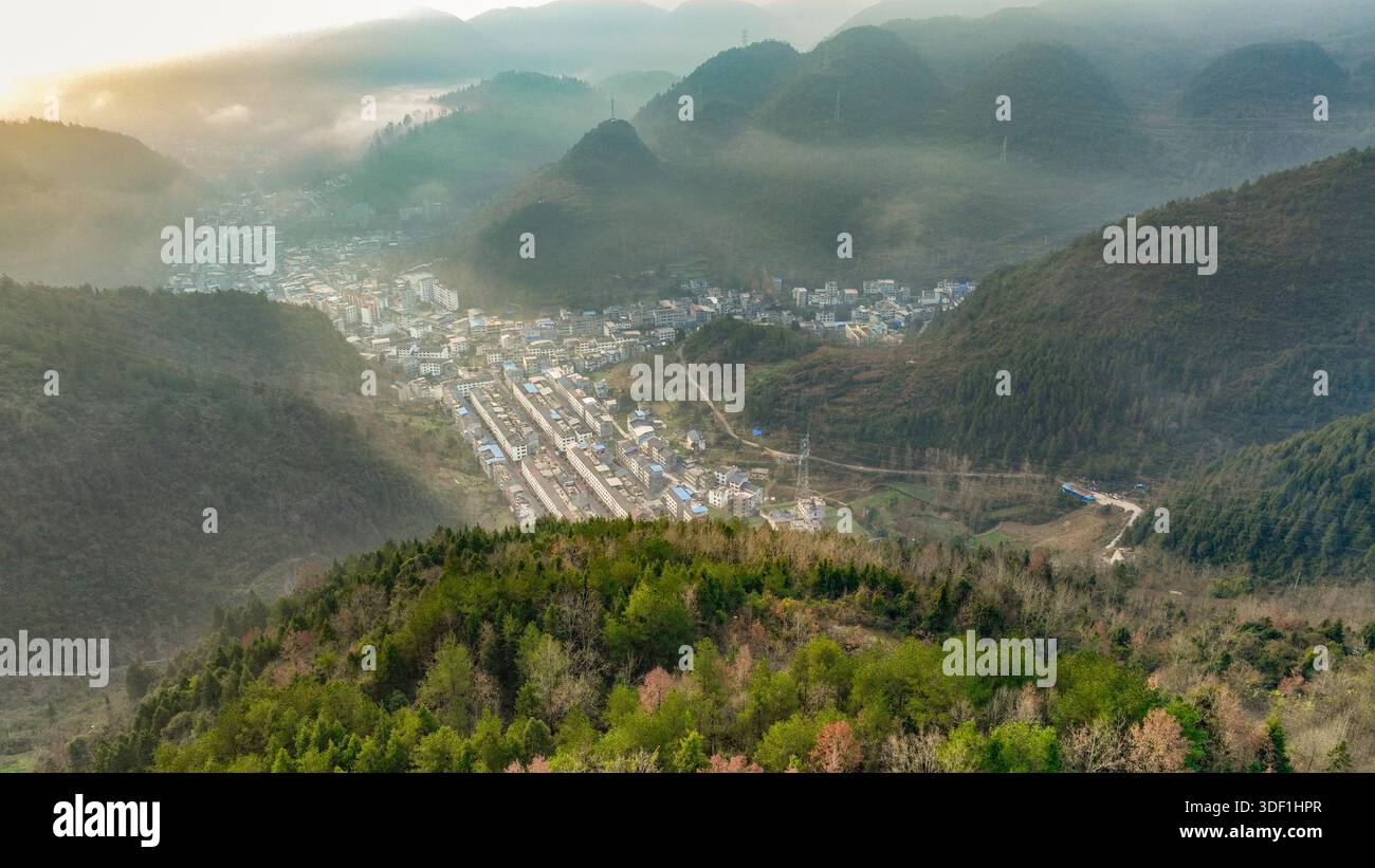 The morning sun rises over mountains as mist lingers in Dingshi Town ...