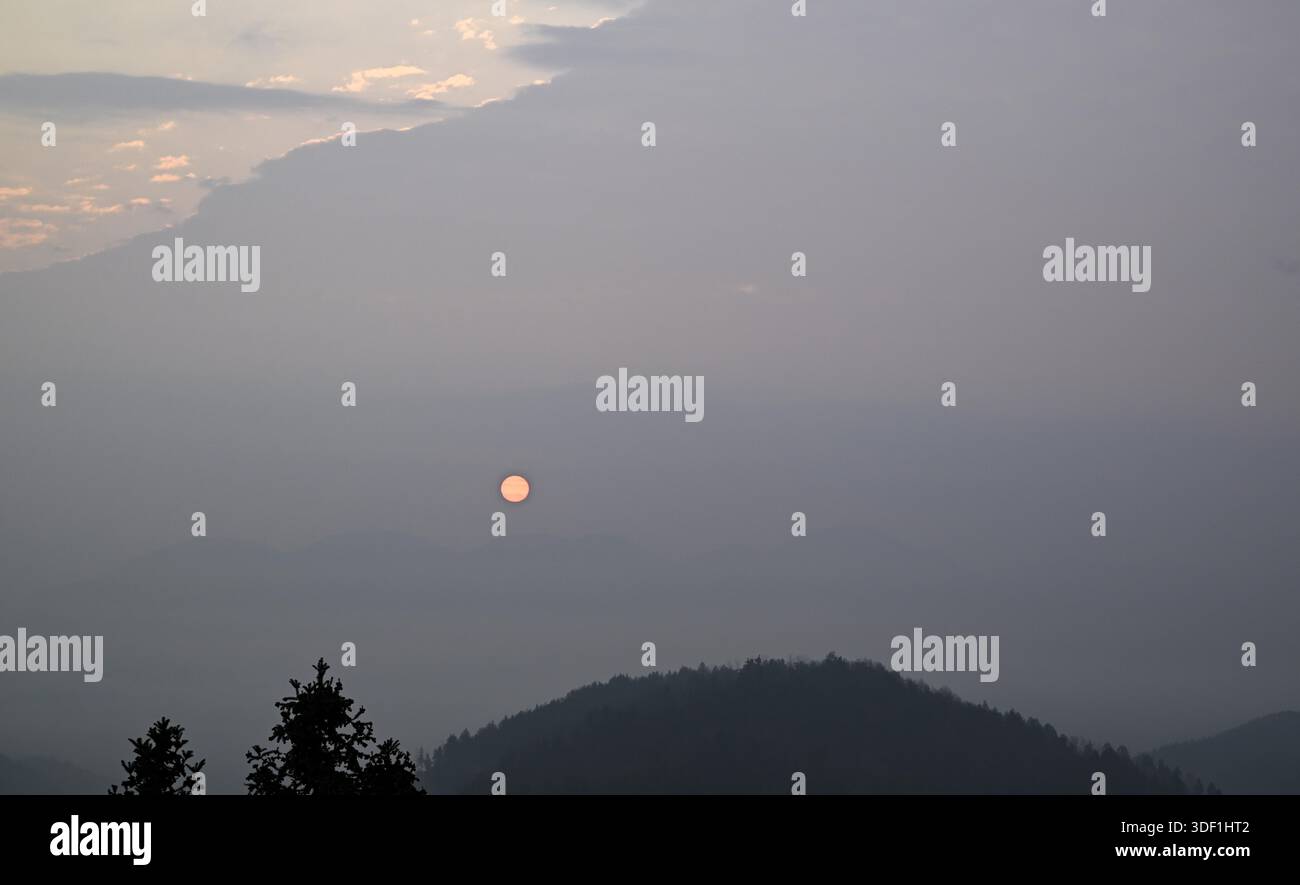 The morning sun rises over mountains as mist lingers in Dingshi Town ...