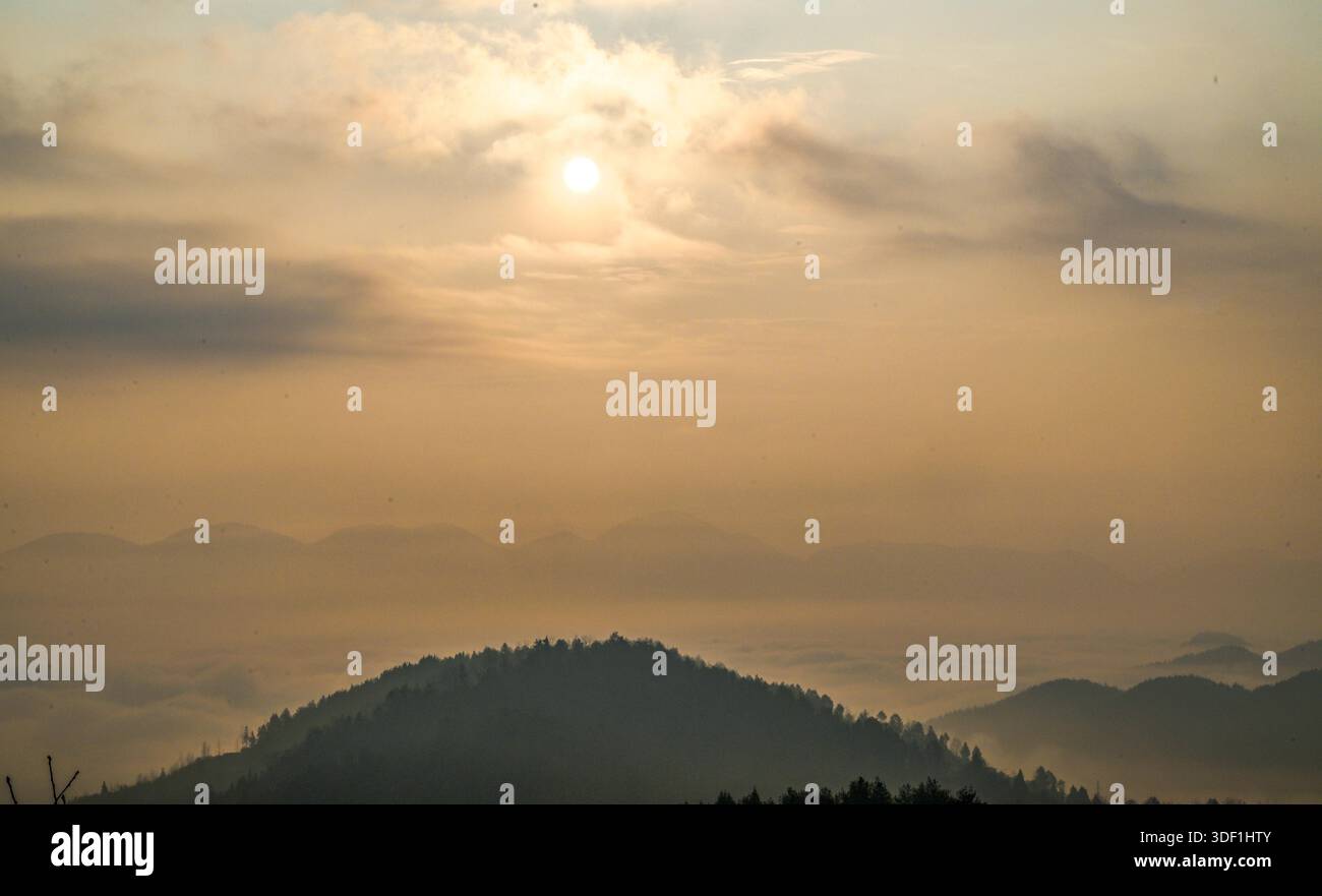 The morning sun rises over mountains as mist lingers in Dingshi Town ...