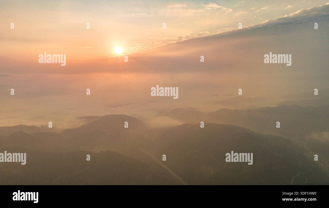 The morning sun rises over mountains as mist lingers in Dingshi Town ...