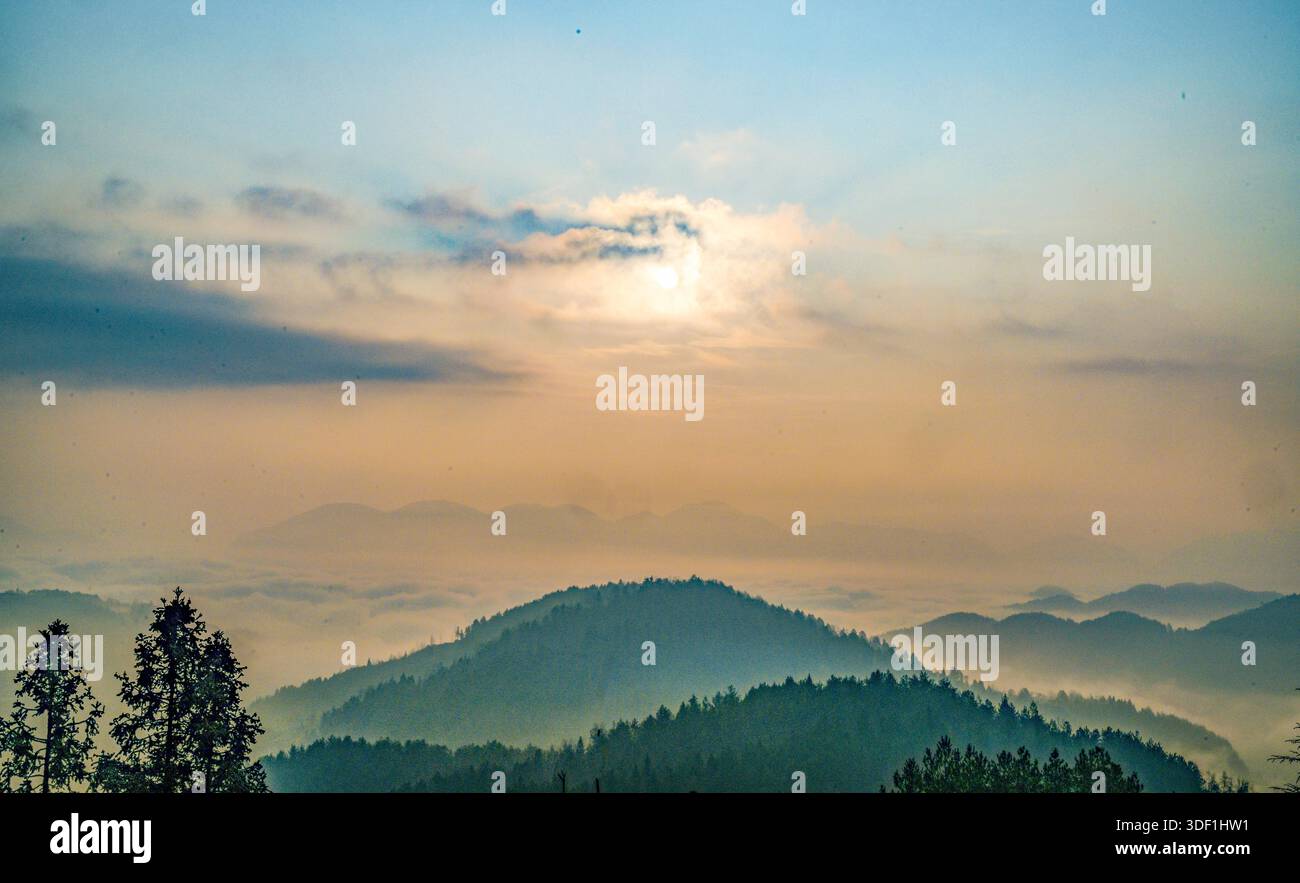 The morning sun rises over mountains as mist lingers in Dingshi Town ...