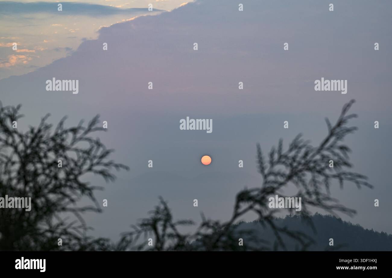 The morning sun rises over mountains as mist lingers in Dingshi Town ...