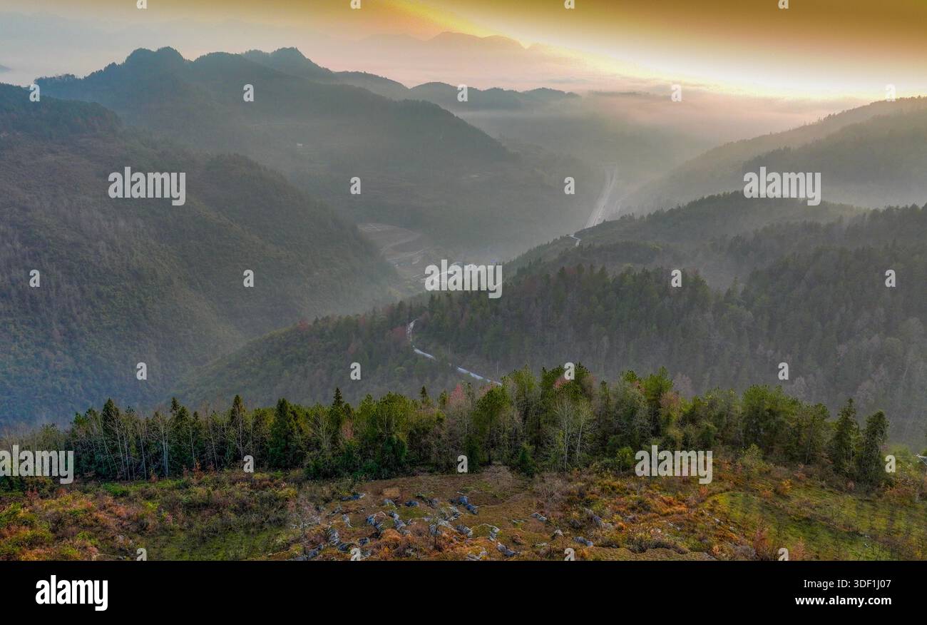 The morning sun rises over mountains as mist lingers in Dingshi Town ...