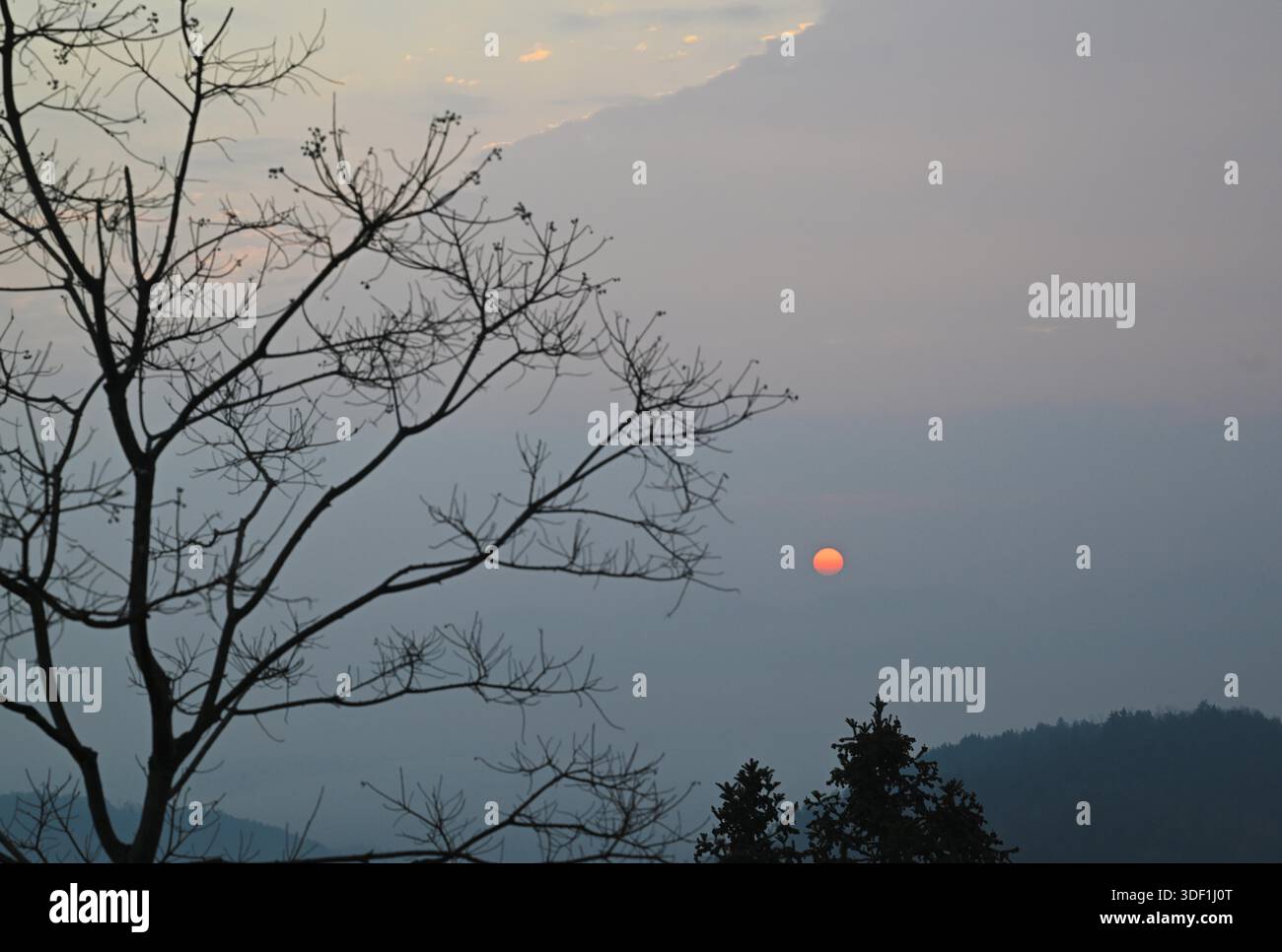 The morning sun rises over mountains as mist lingers in Dingshi Town ...