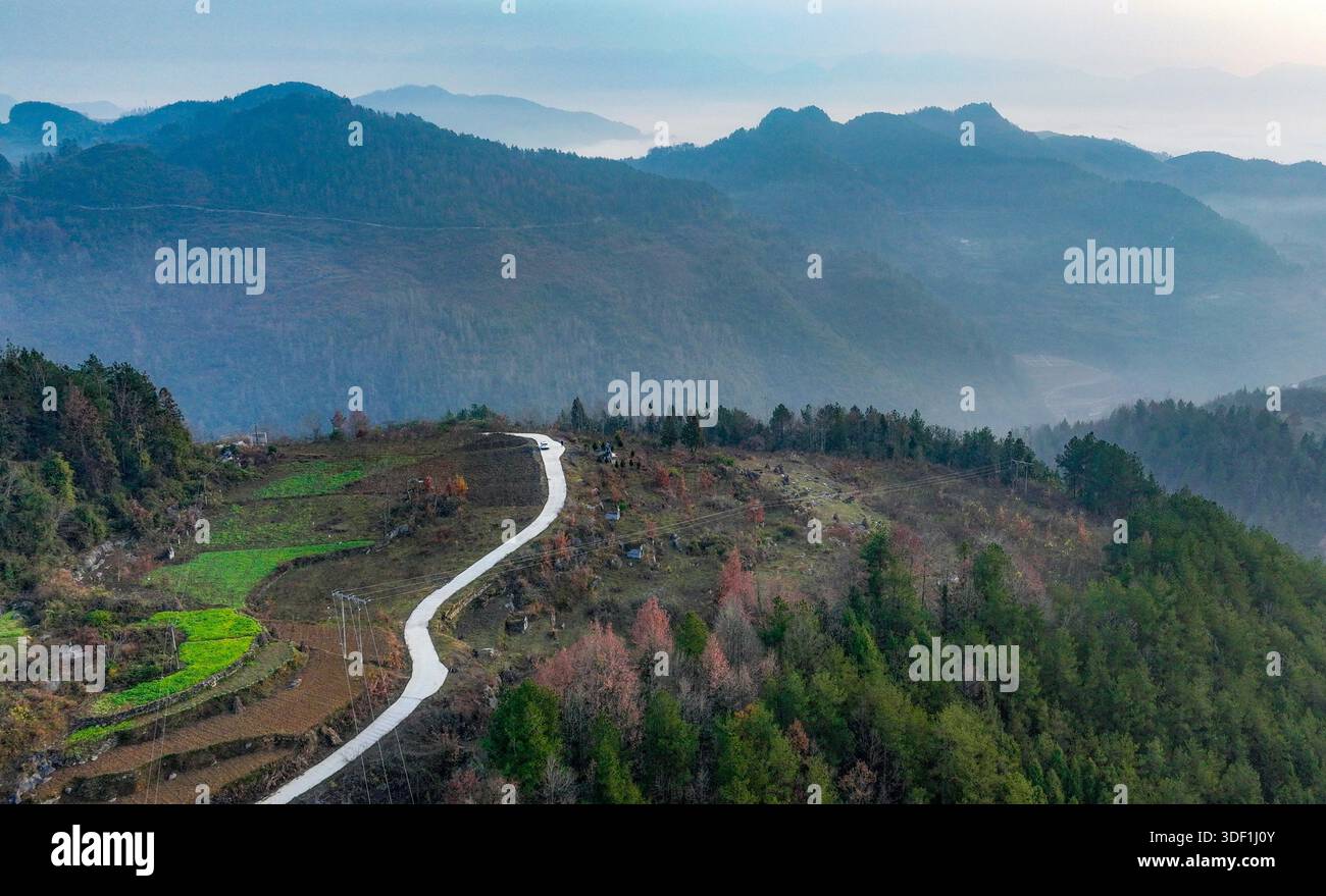 The morning sun rises over mountains as mist lingers in Dingshi Town ...