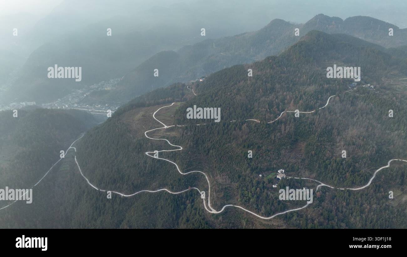 The morning sun rises over mountains as mist lingers in Dingshi Town ...