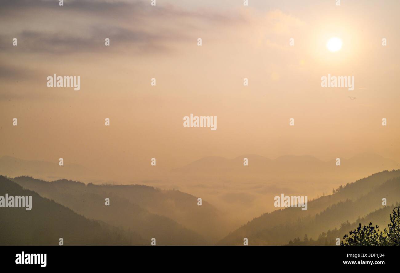 The morning sun rises over mountains as mist lingers in Dingshi Town ...