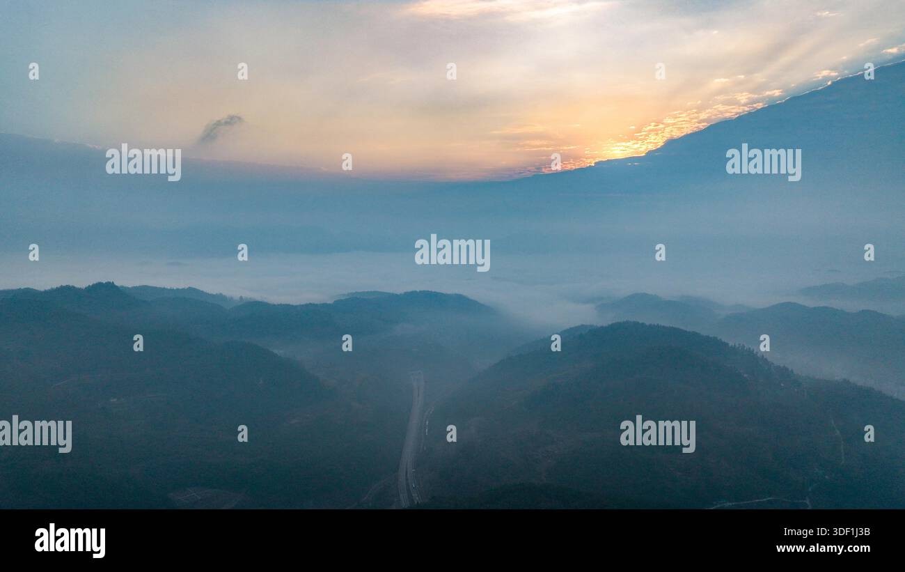 The morning sun rises over mountains as mist lingers in Dingshi Town ...