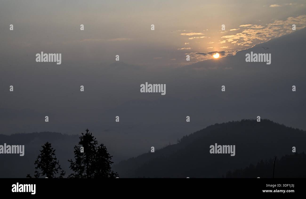 The morning sun rises over mountains as mist lingers in Dingshi Town ...