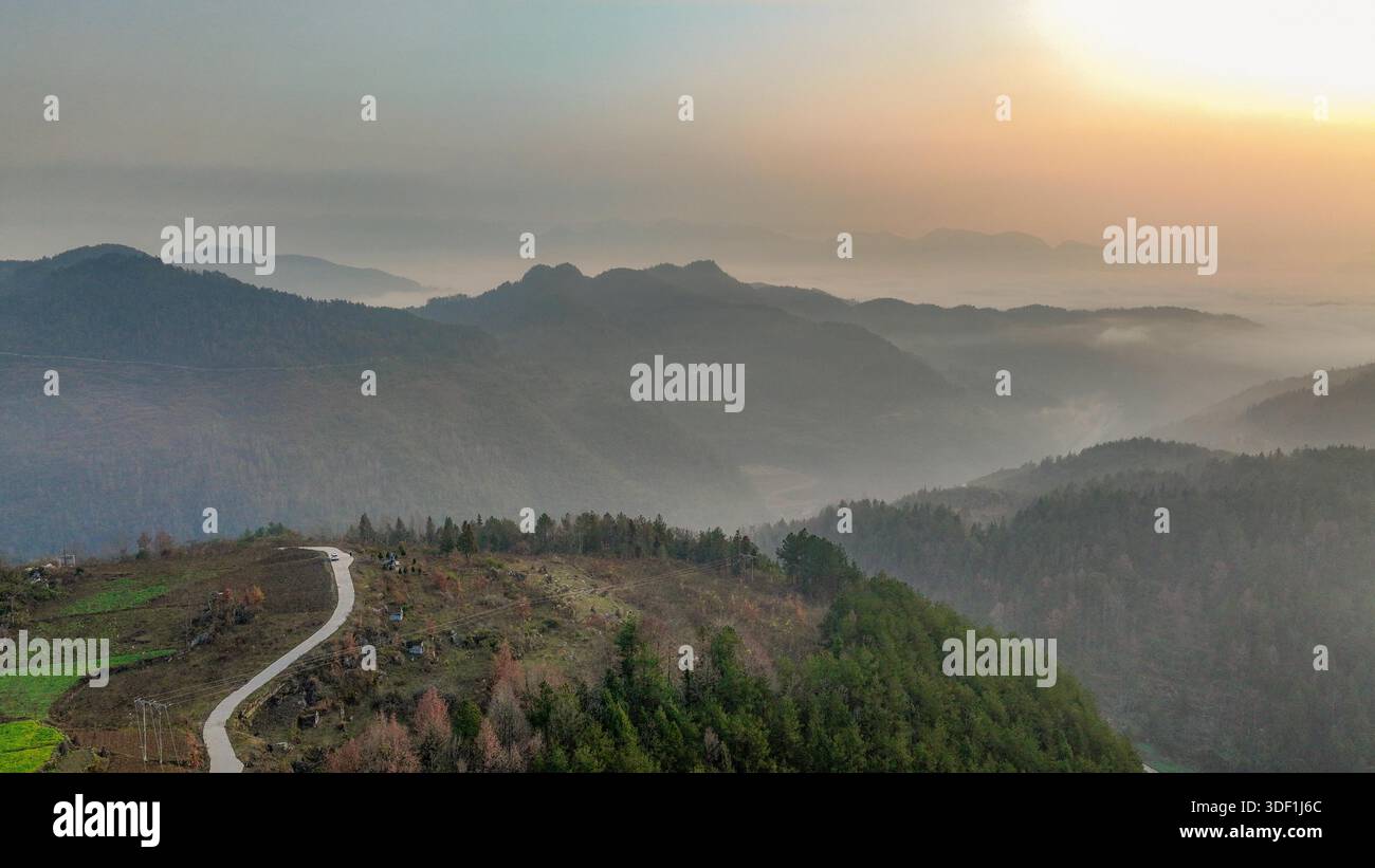The morning sun rises over mountains as mist lingers in Dingshi Town ...