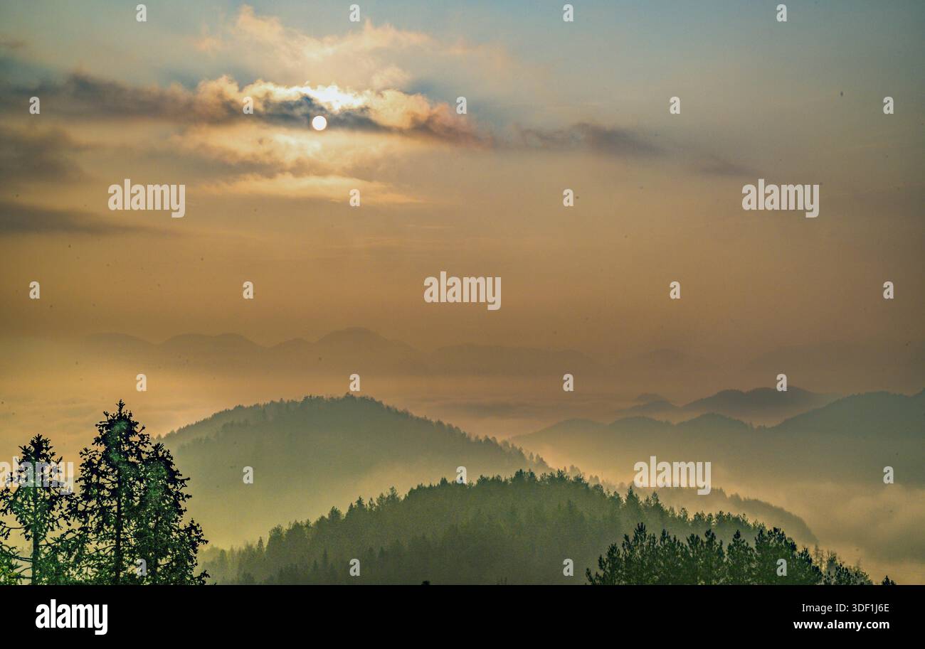The morning sun rises over mountains as mist lingers in Dingshi Town ...