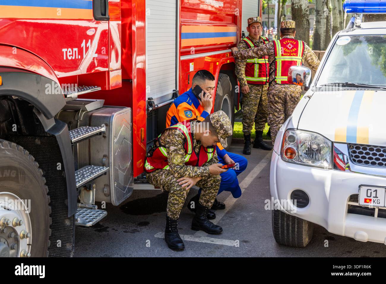 Four Asian firefighters and rescuers in uniforms near emergency ...
