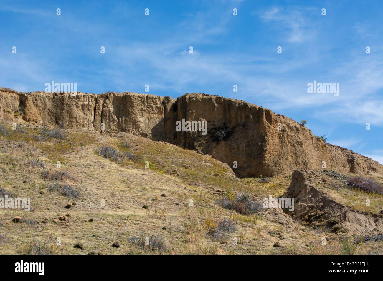A rugged cliffside with a clear blue sky above. The landscape features ...