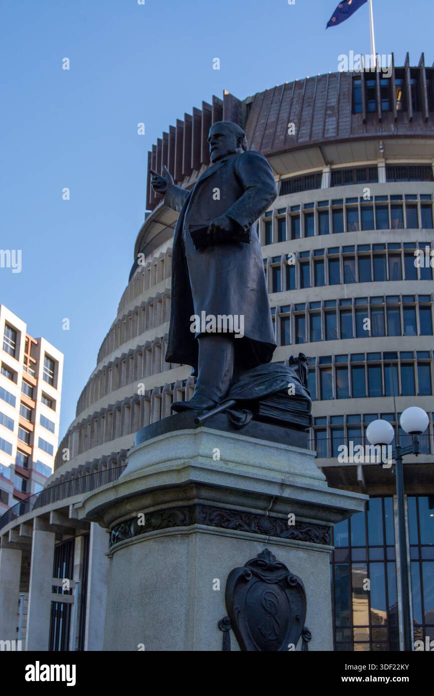 A statue of a historical figure stands prominently in front of a modern ...