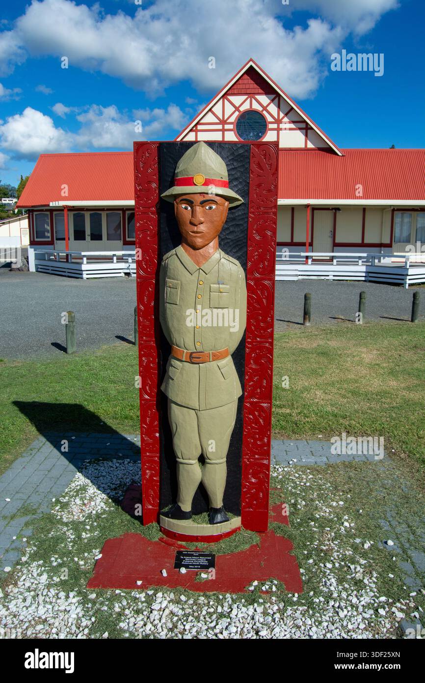 A carved wooden statue of a soldier in a uniform, standing upright. The ...