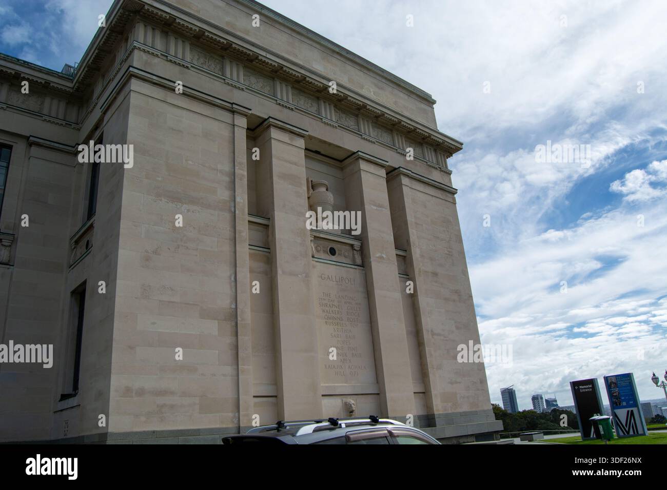 A close-up view of a large stone building featuring classical ...