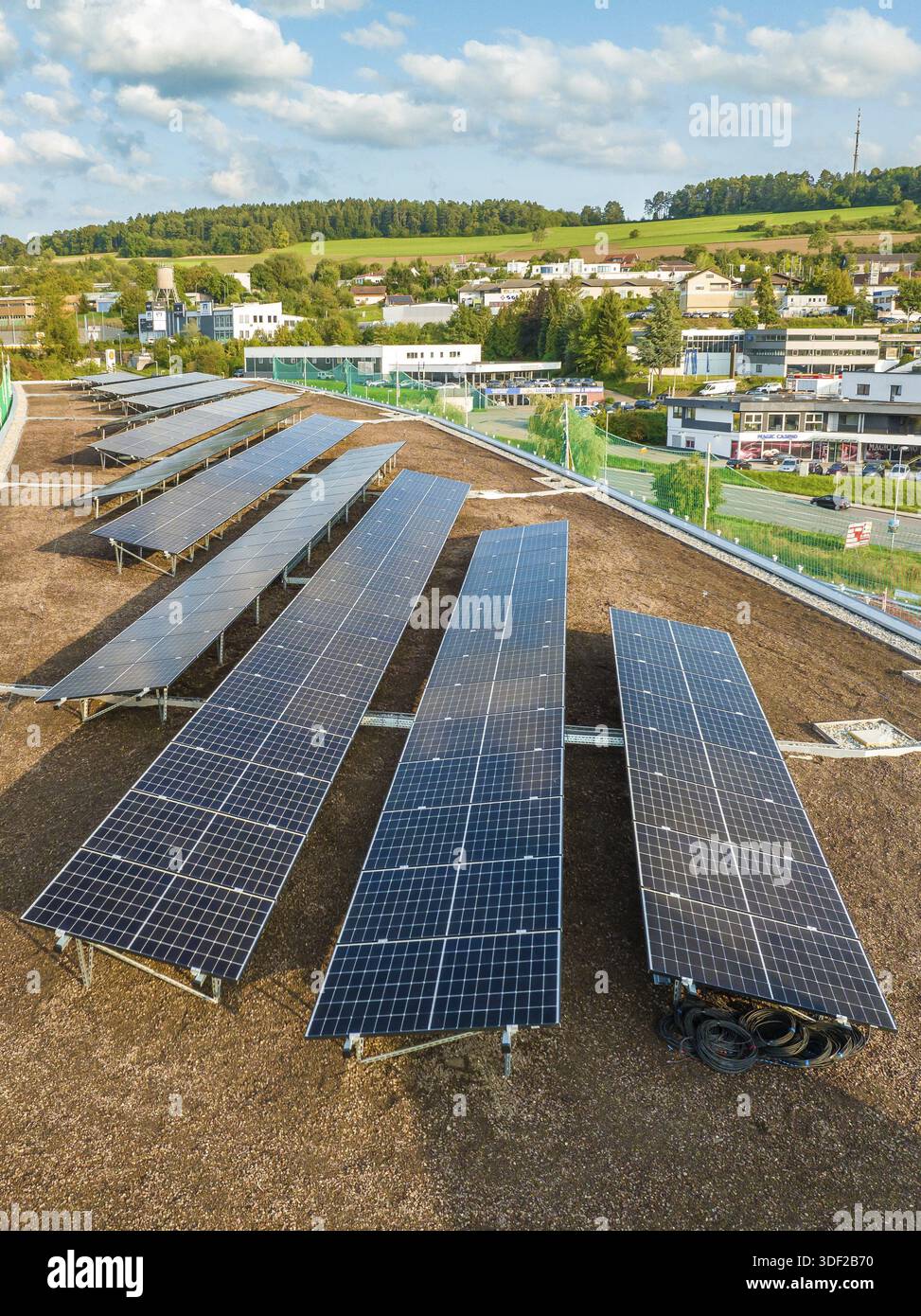 Rows of solar modules with views of the surrounding area and green ...