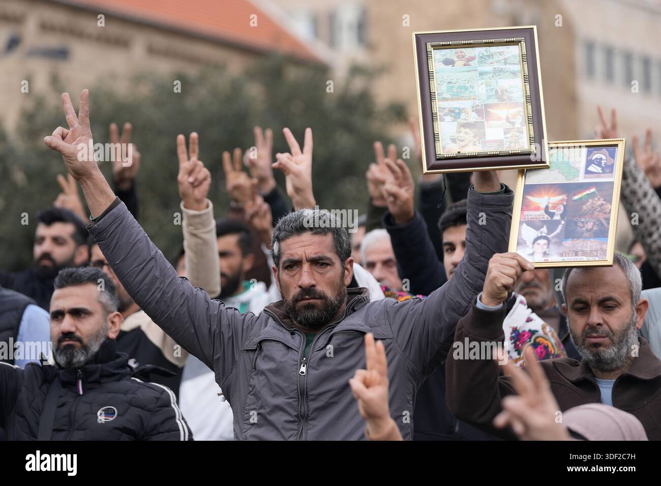 Kurdish citizens flash victory signs during a protest against the ...