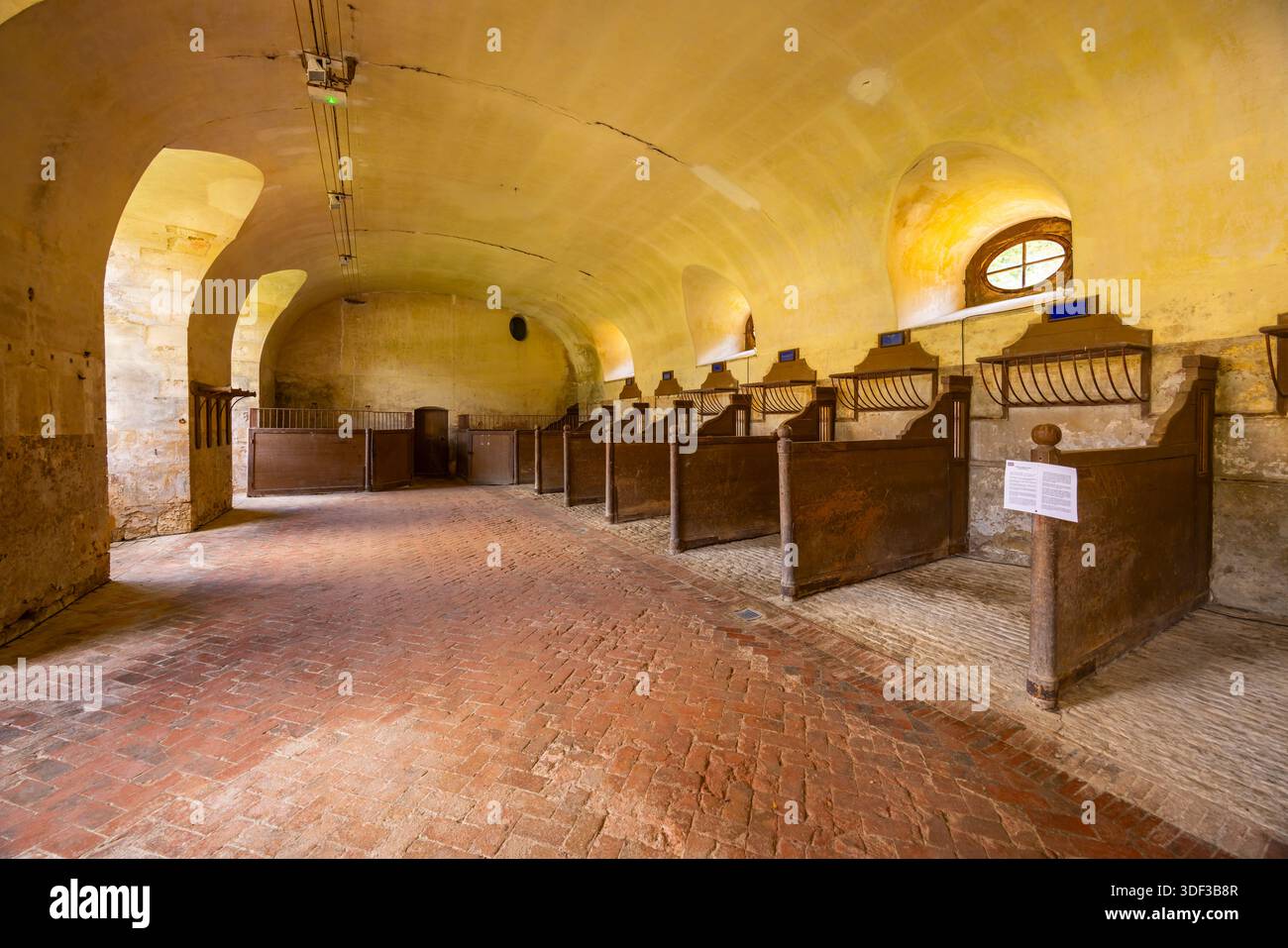 Vaulted stable building in Chateau de Commarin showing old brick floor ...