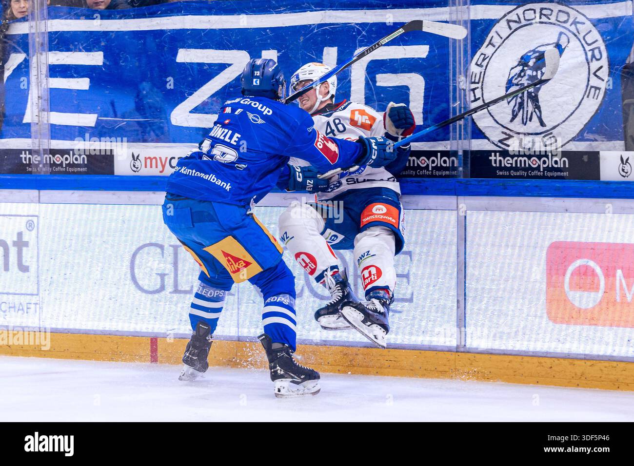 Mike Kunzle #73 (EV Zug) pushes Dean Kukan #46 (ZSC Lions) against the ...
